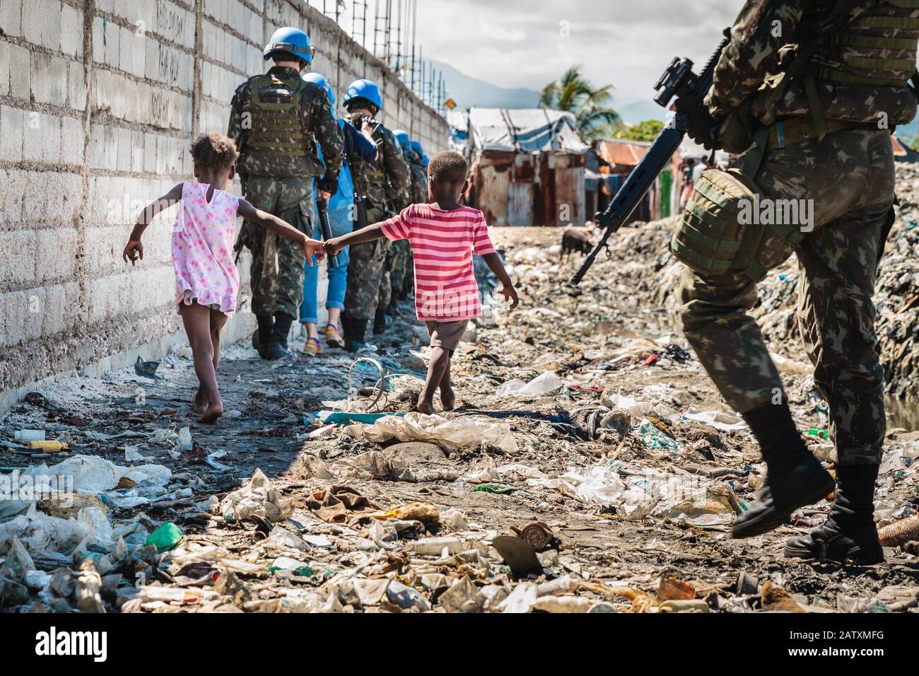 Two children and UN patrol, blue helmets, walking through garbage, Cite ...