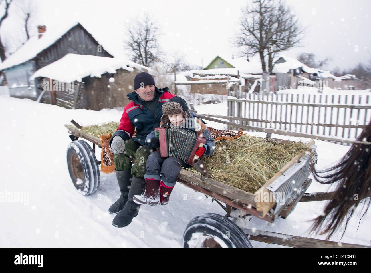The village child and grandfather ride a horse-drawn cart. Russian ...