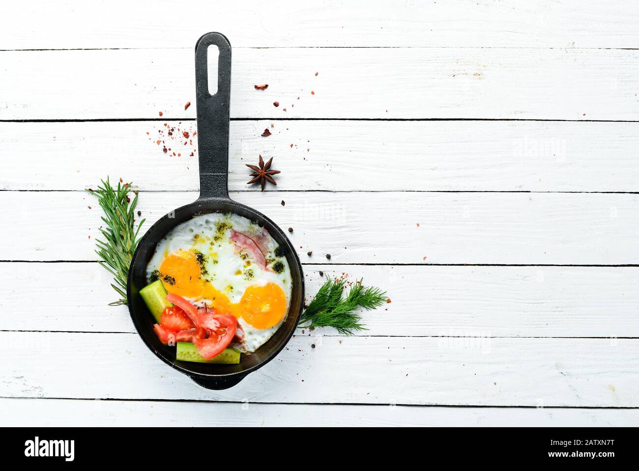 Breakfast. Fried eggs with bacon and vegetables in a frying pan. Top view. Free copy space Stock ...