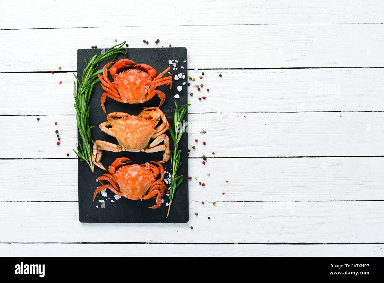 Boiled crabs with spices on a white wooden background. Top view. Free space for your text Stock ...