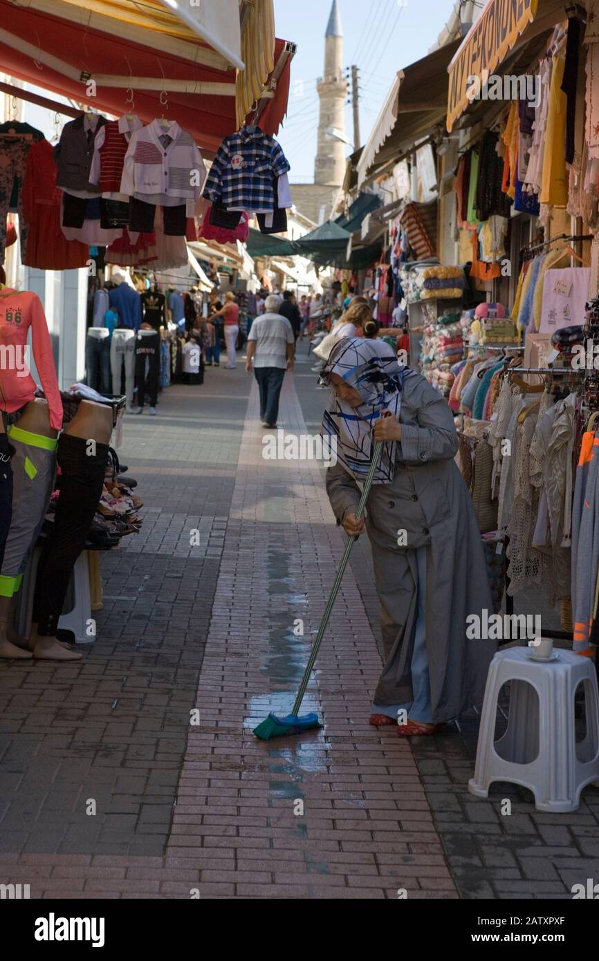 Old lady sweeps the street outside her market stall, Arasta Sokaği ...