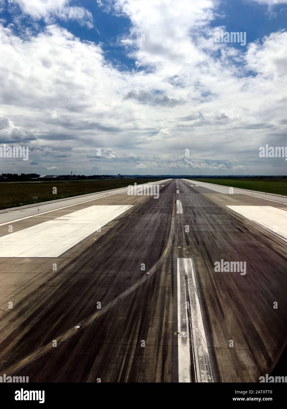 Concrete runway in diminishing perspective with black tire marks and ...