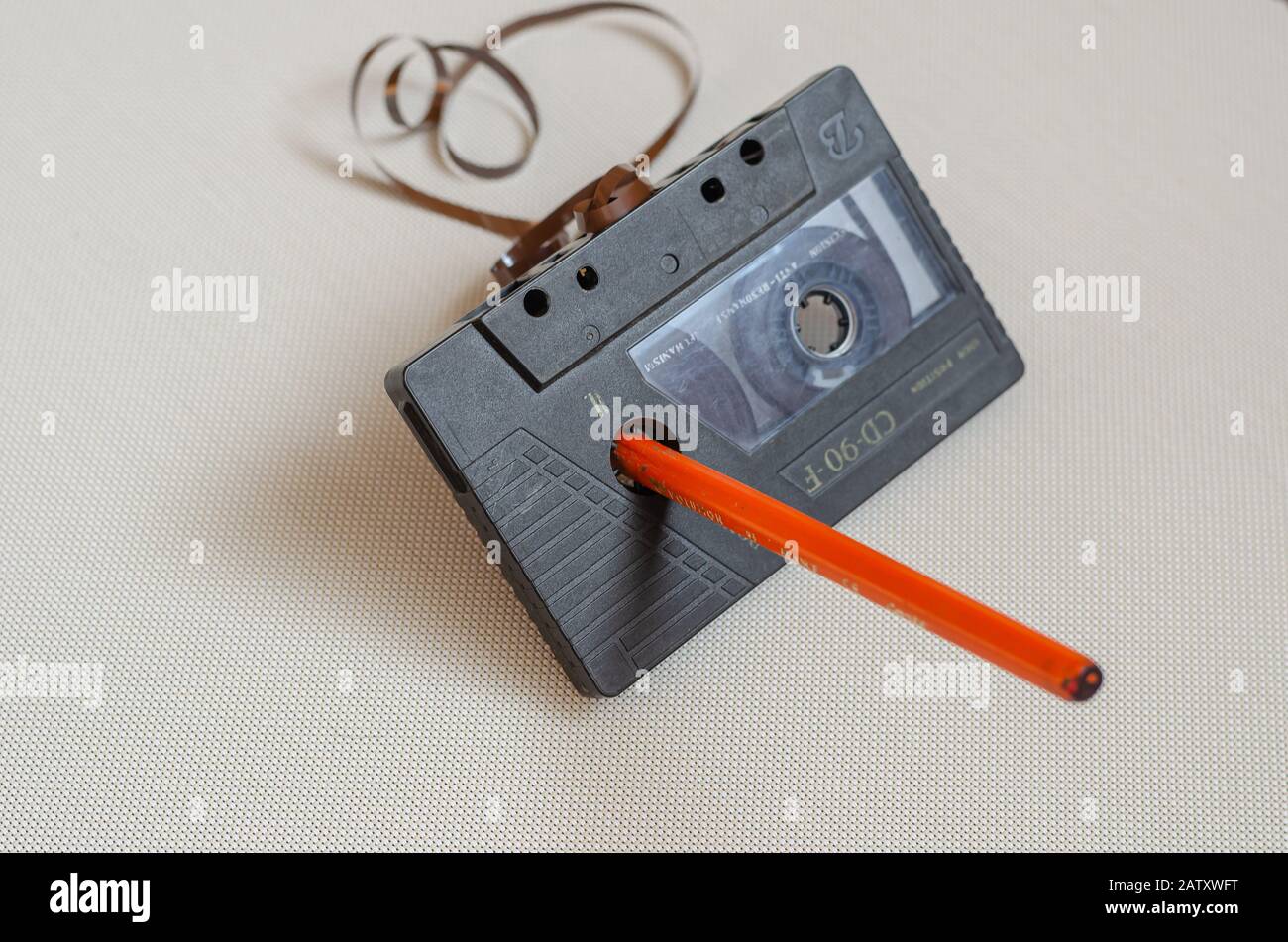 Old Black Audio Cassette And Orange Pencil On A Light Table Home Audio