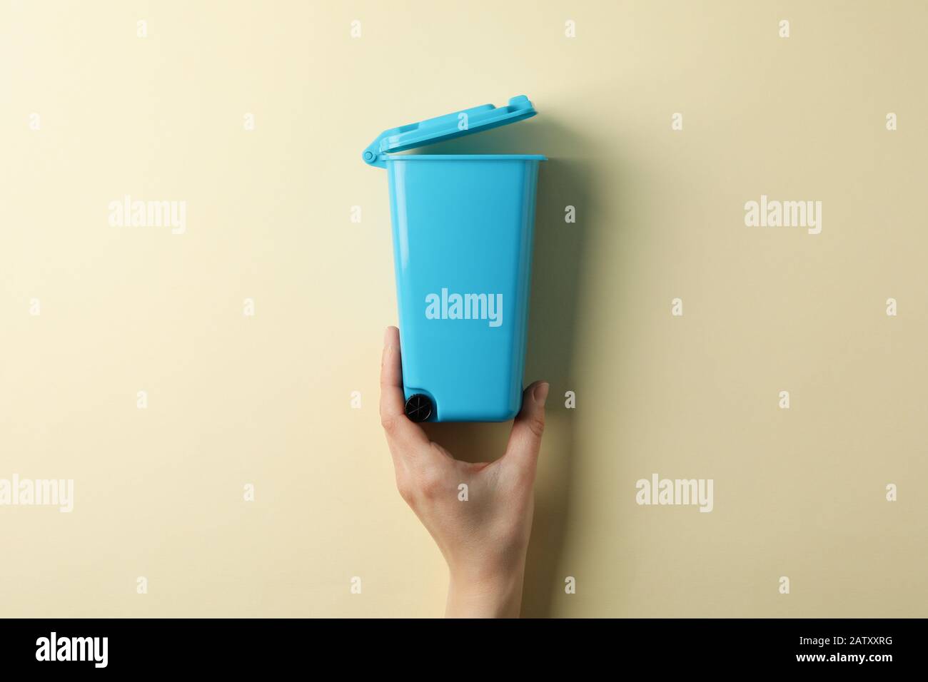 Female hand holding recycle bin on beige background, top view Stock ...