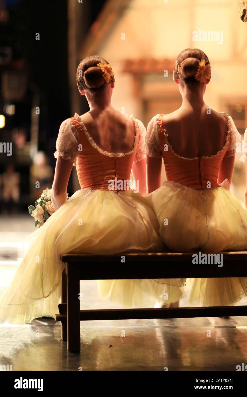 Two ballet dancers from the Corps de Ballet are sitting on a bench ...