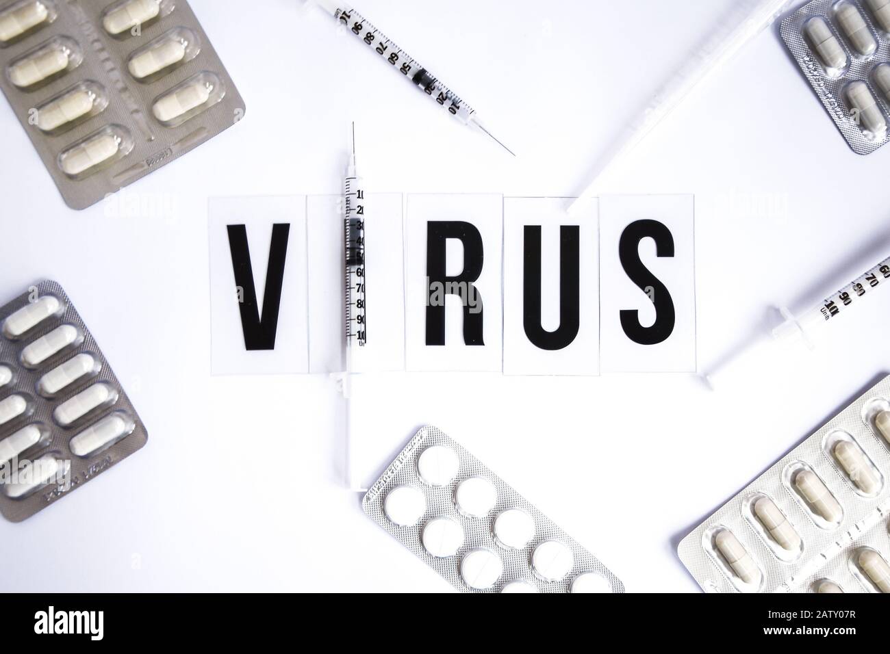 The word virus on a white background with syringe pills, medicines ...