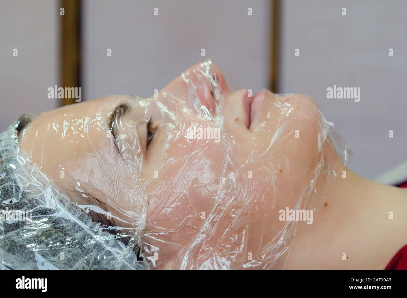 Woman face covered with plastic wrap in the beauty salon Stock Photo ...