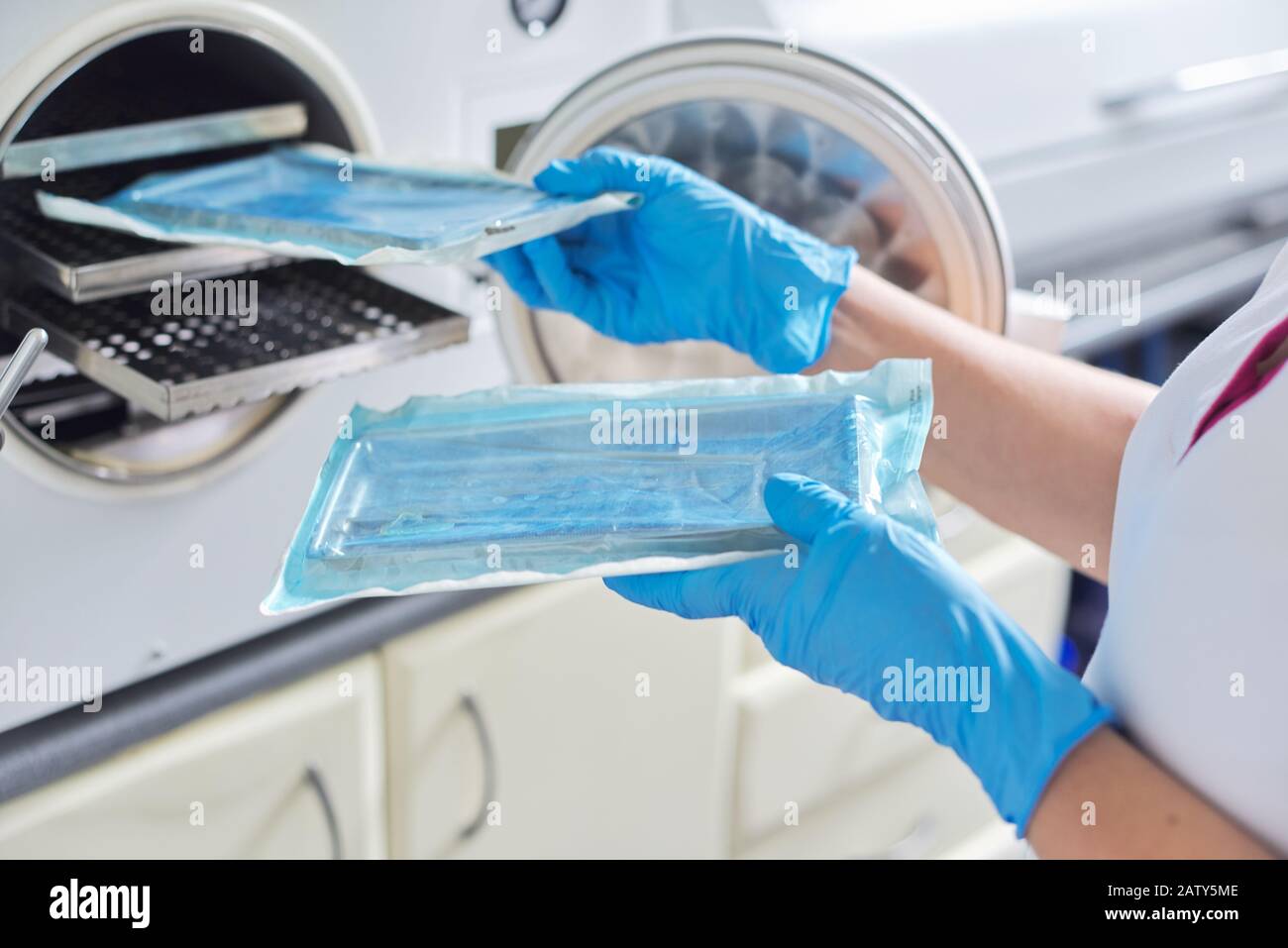 Female nurse doing sterilization of dental medical instruments in ...