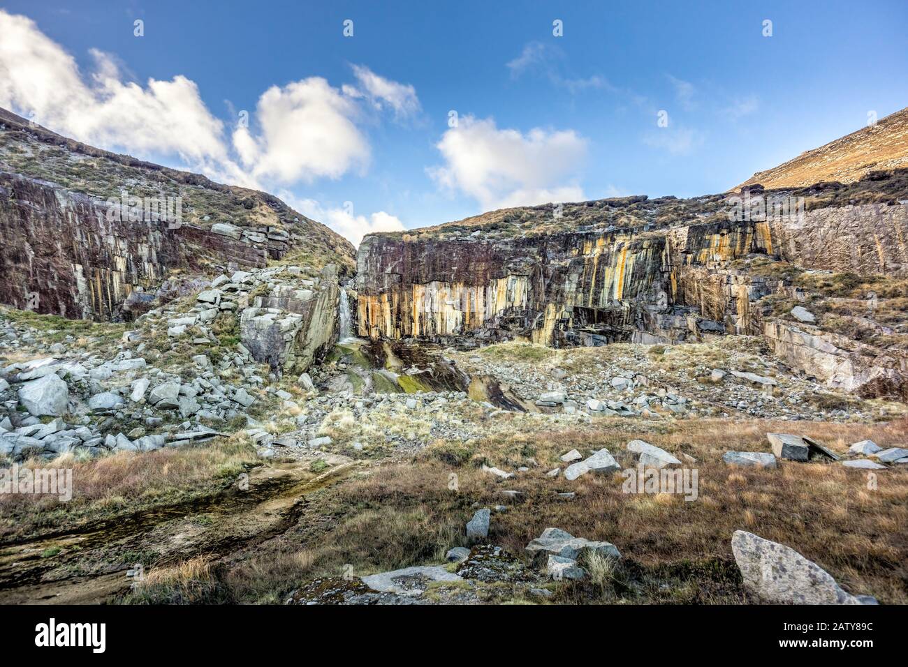 Old stone quarry with waterfall in Mourne Mountains near Slieve Donard ...