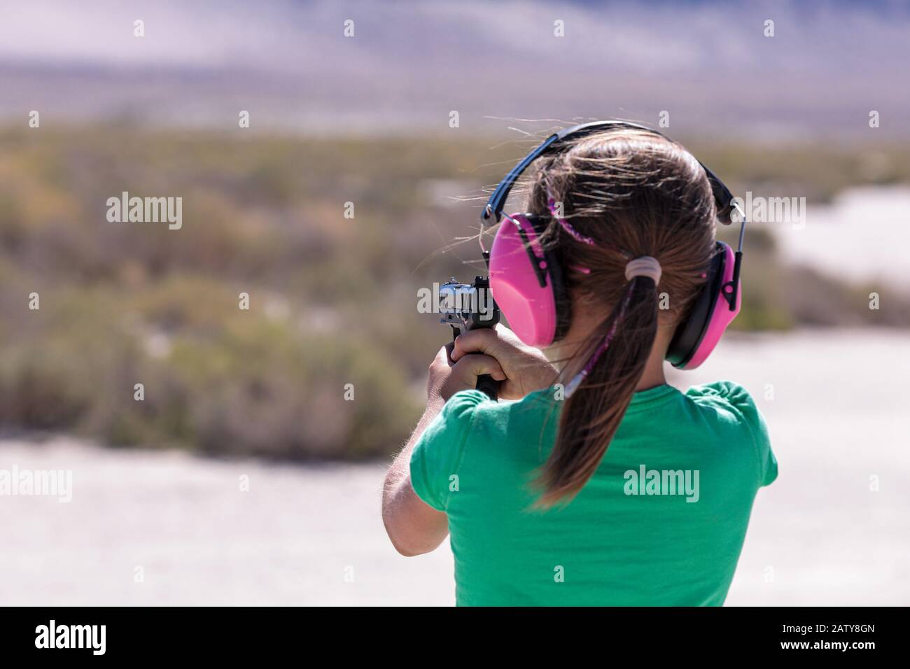 Little girl practicing target shooting with 22LR caliber pistol in ...