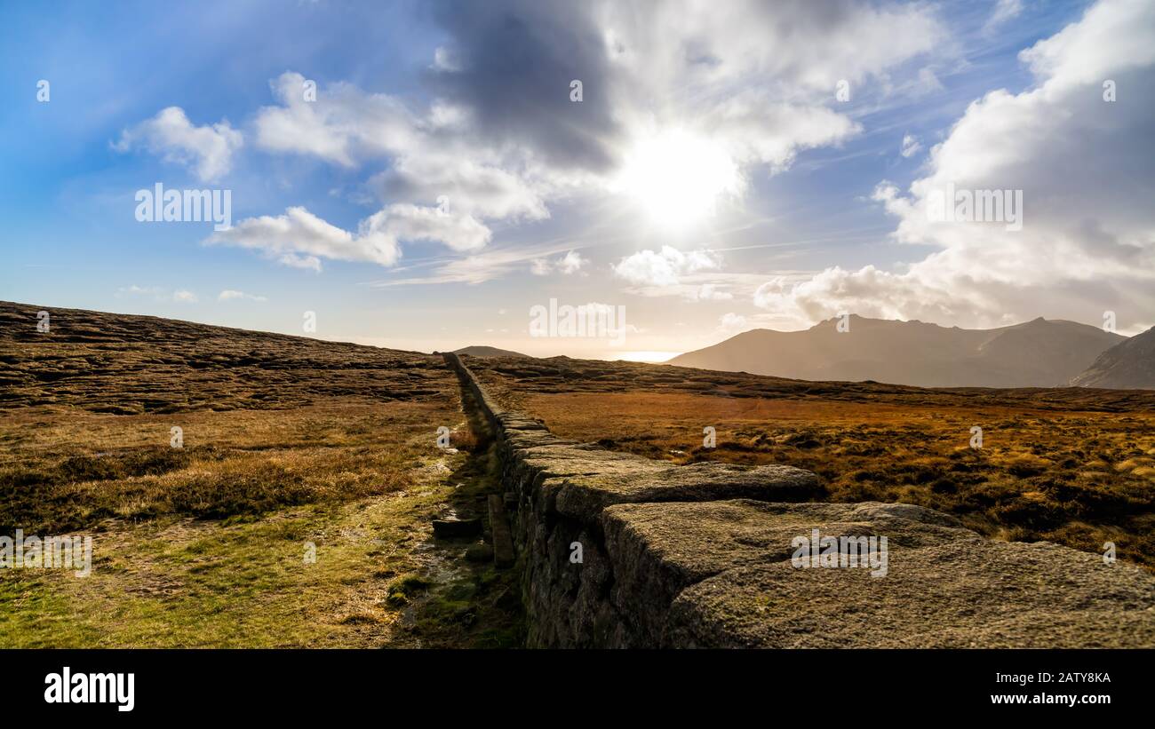 Mourn Wall on the bank of Slieve Donard mountain with blue sky, white ...