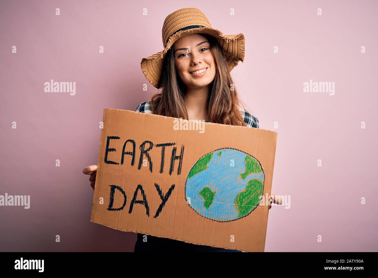 Young beautiful woman asking for planet conservation holding cardboard ...