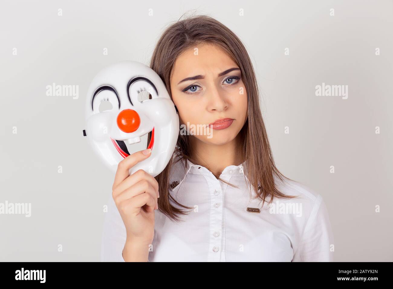 Wearing a mask, faking it concept. Closeup portrait worried girl with ...