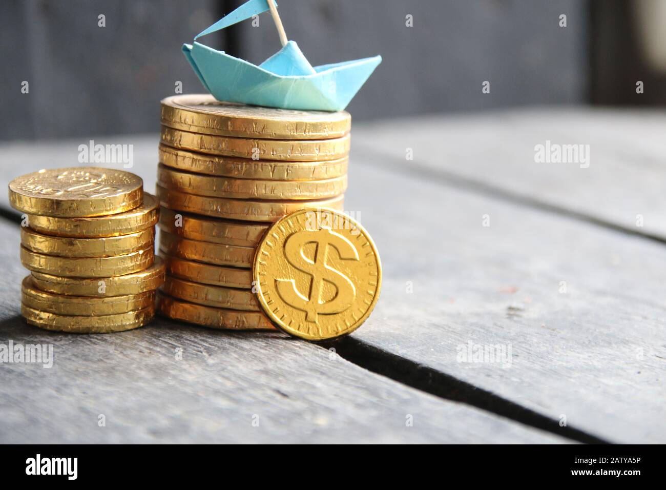 graph of gold coins and a paper boat Stock Photo - Alamy
