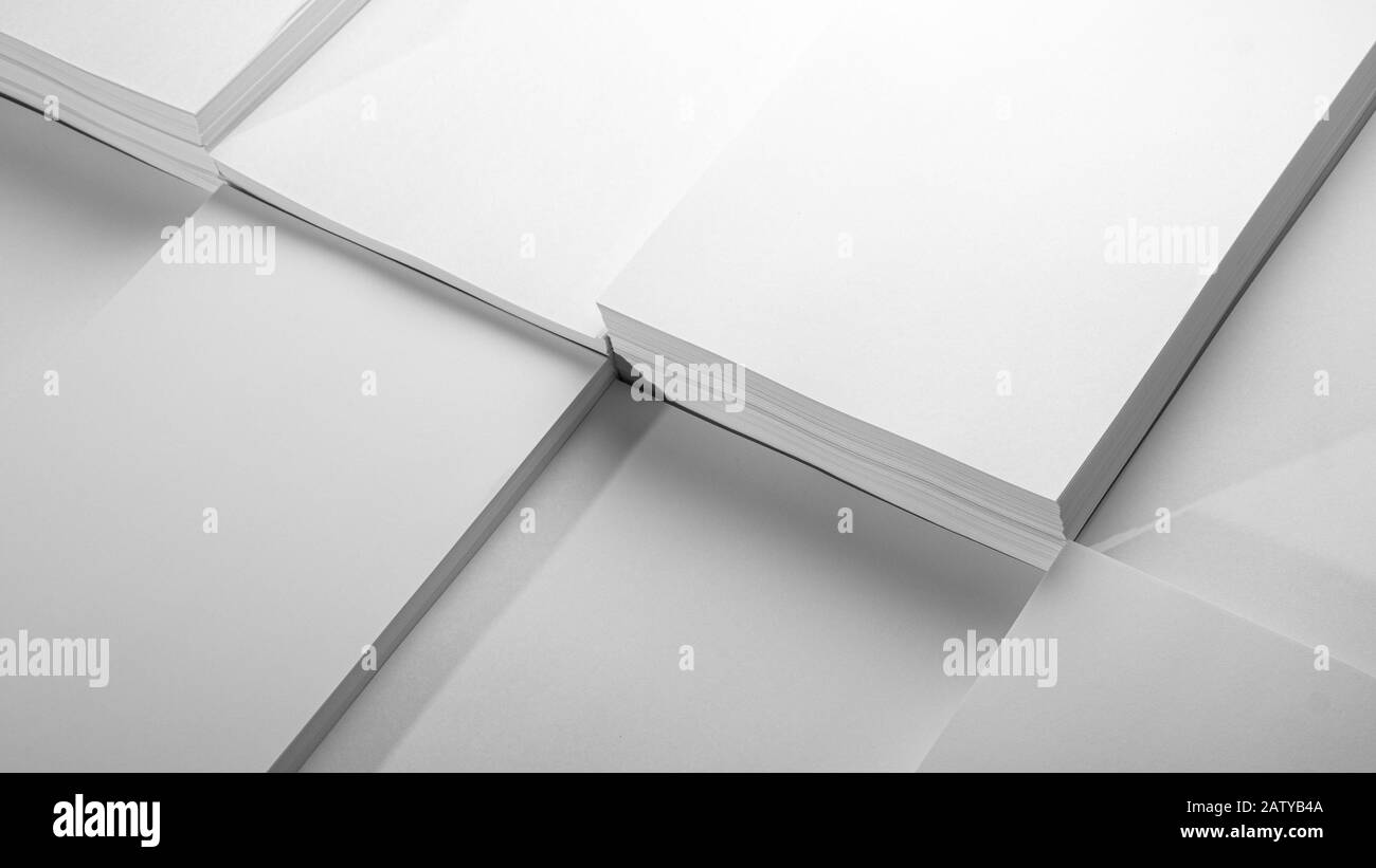 Several stacks of white paper on a white background Stock Photo - Alamy