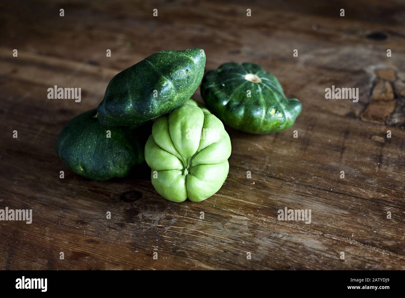 Round green squashes from the garden piled up on the rustic wooden ...
