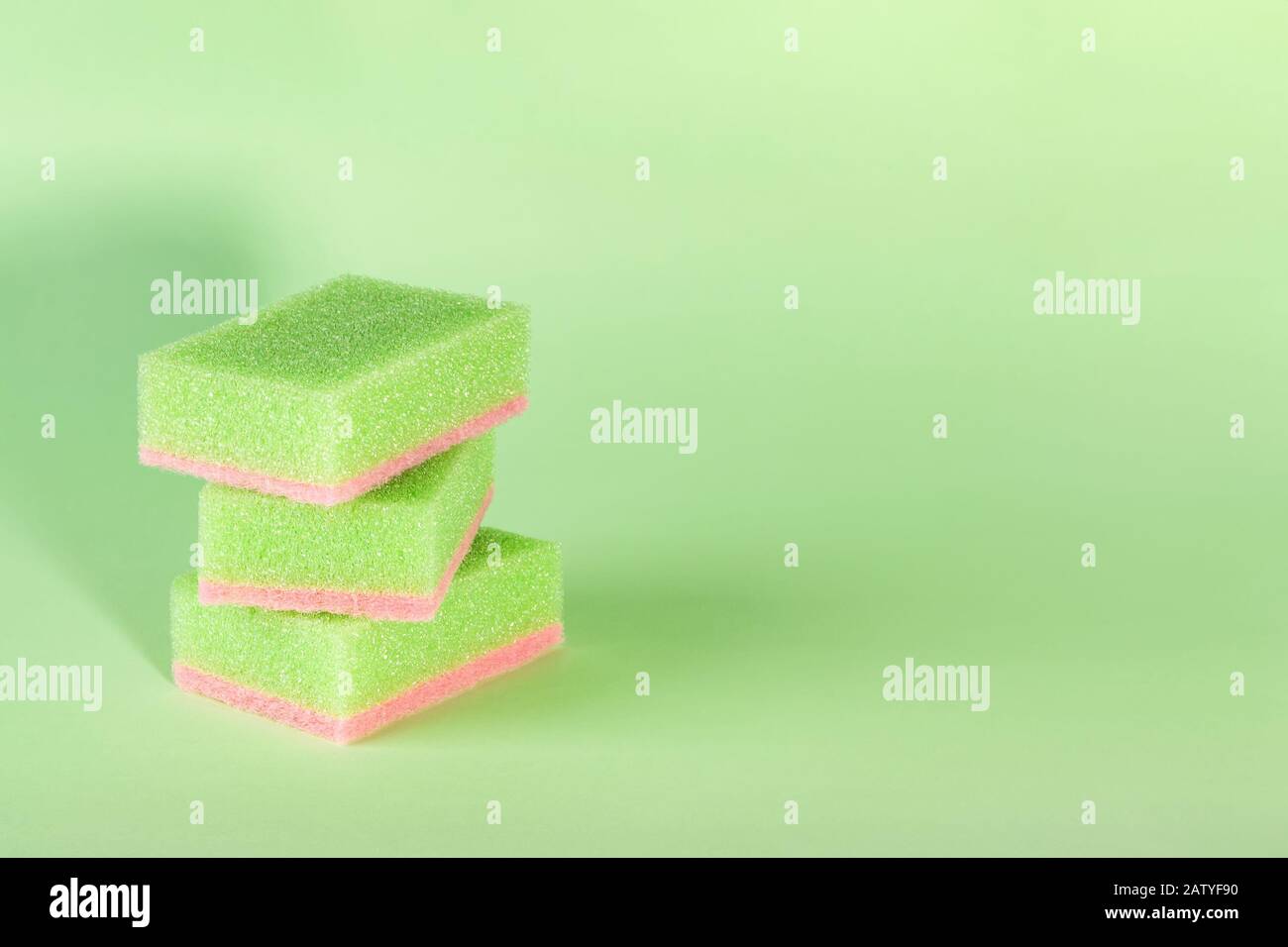 Three green pink kitchen foam sponges on a green background. Sponge for ...