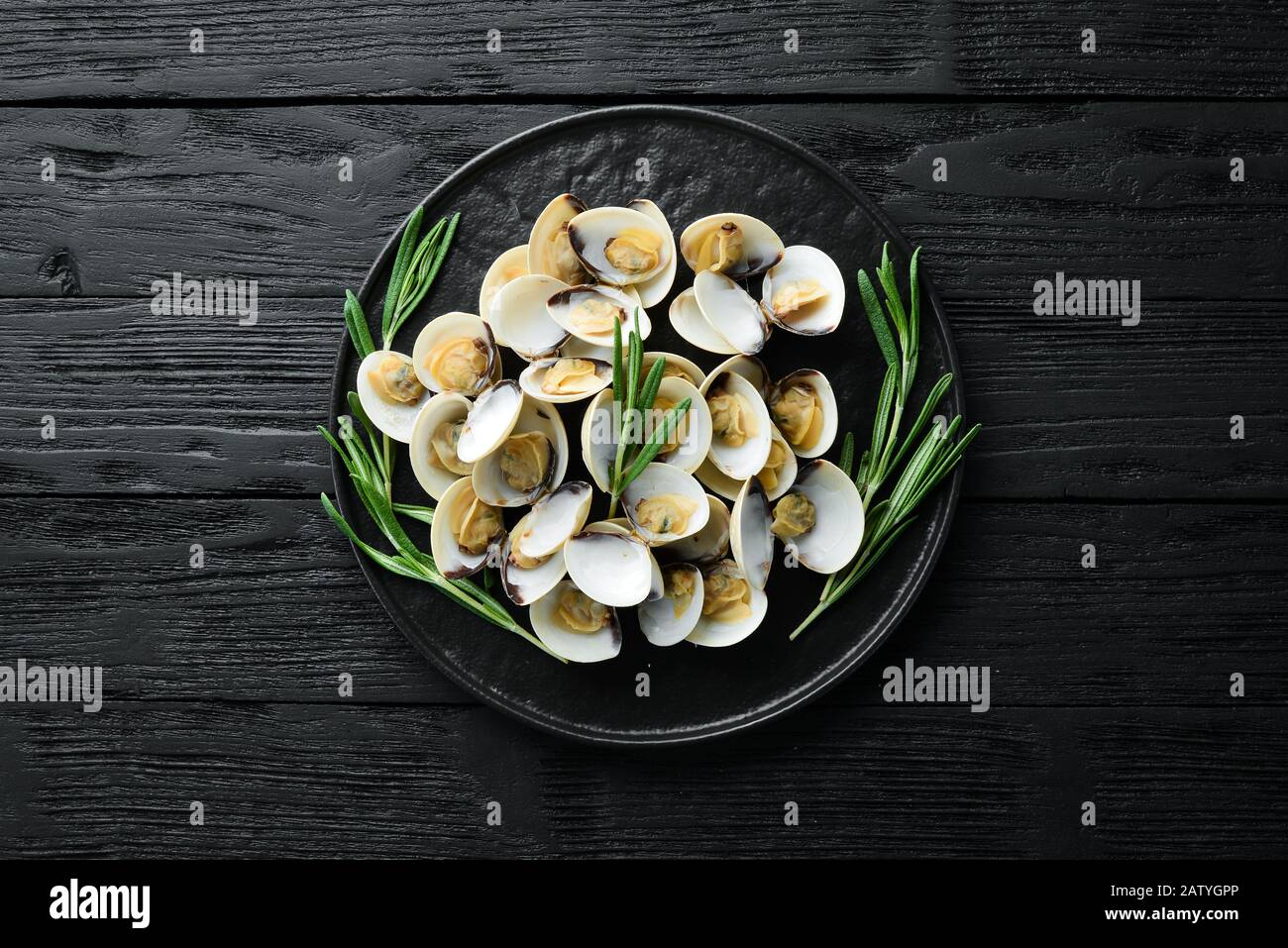Boiled clams with spices in a plate. Seafood on black background. Top ...