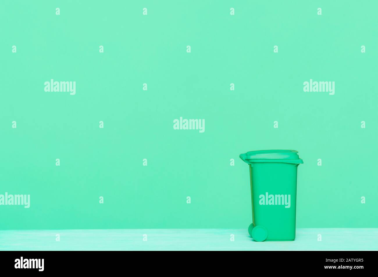 Green recycle bin on green background, great for recycling concepts and ...