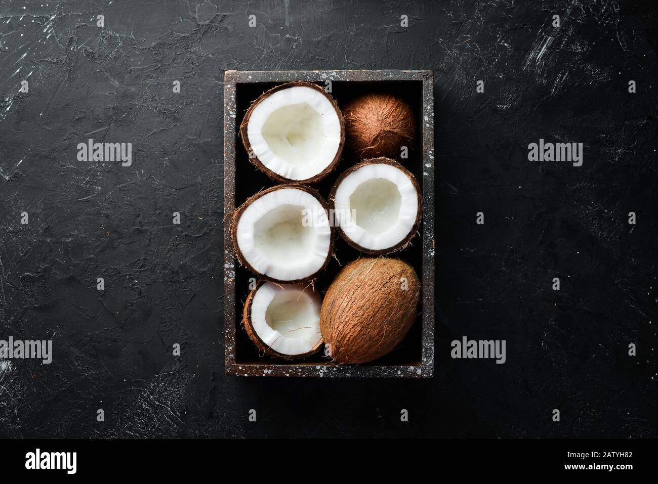 Coconut in a wooden box. Tropical Fruits. Nut. Top view. Free space for ...