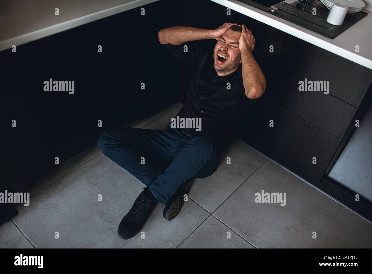 Colorful picture of mad desparate man sitting on floor in kitchen and ...