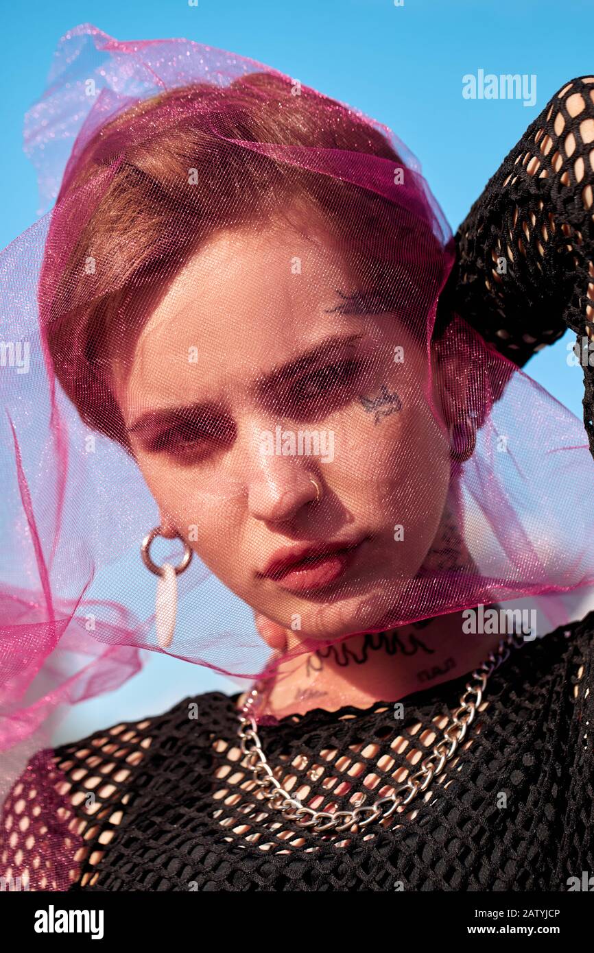 Urban Style. Young stylish woman standing outdoors face under veil ...