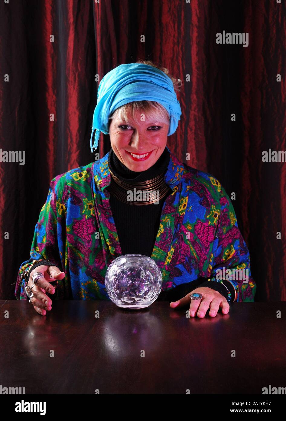 Mysterious woman with crystal ball smiling at camera Stock Photo - Alamy