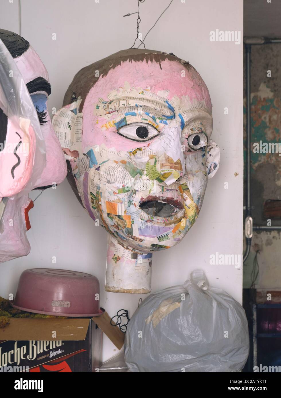 Giant papier mache heads hanging in a Mexican workshop, partially ...