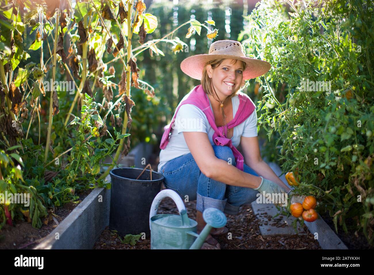 Portrait of a smiling mid-adult woman tending to her garden Stock Photo ...