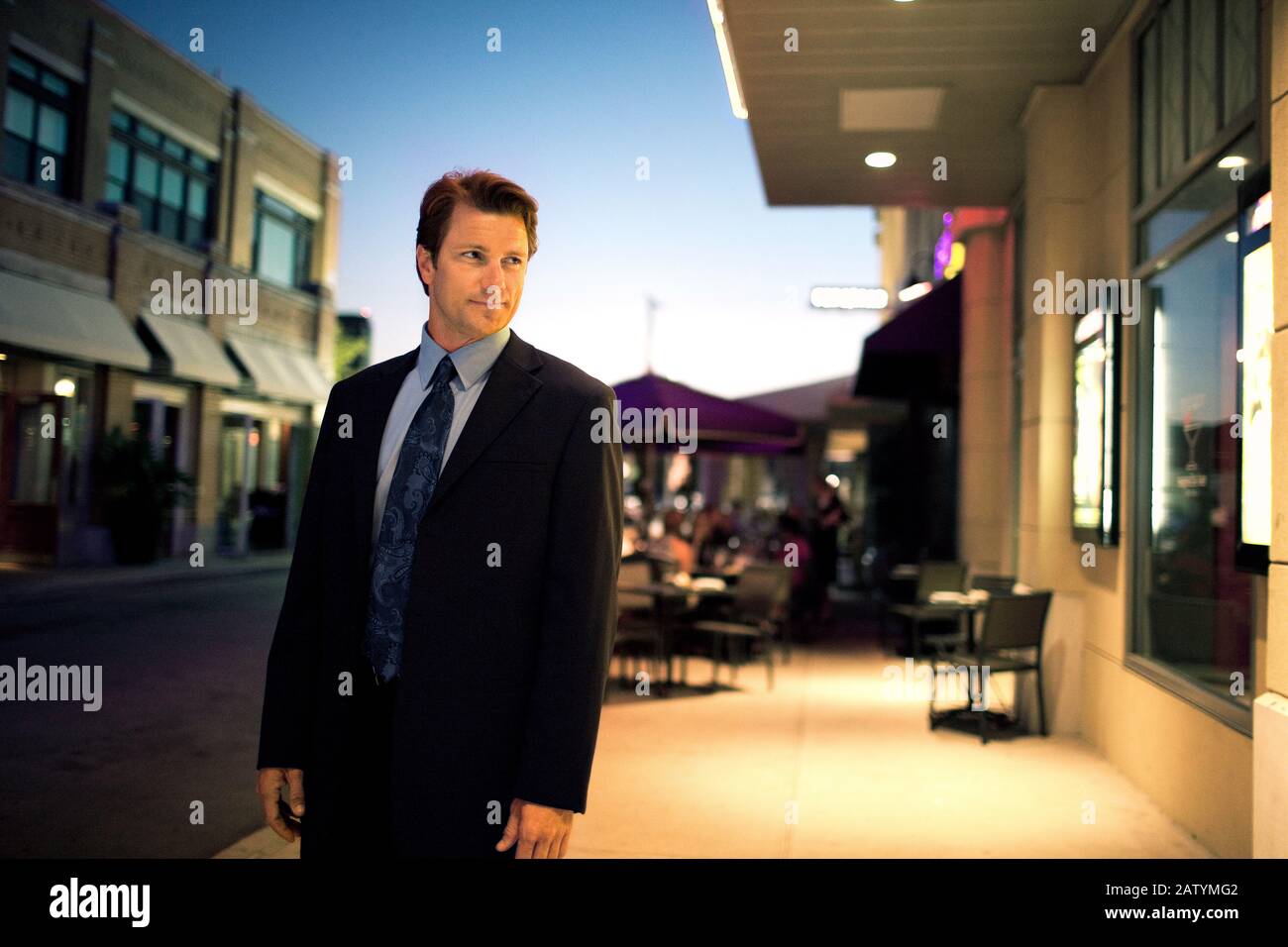 Handsome young businessman waits outside a restaurant for his date to ...