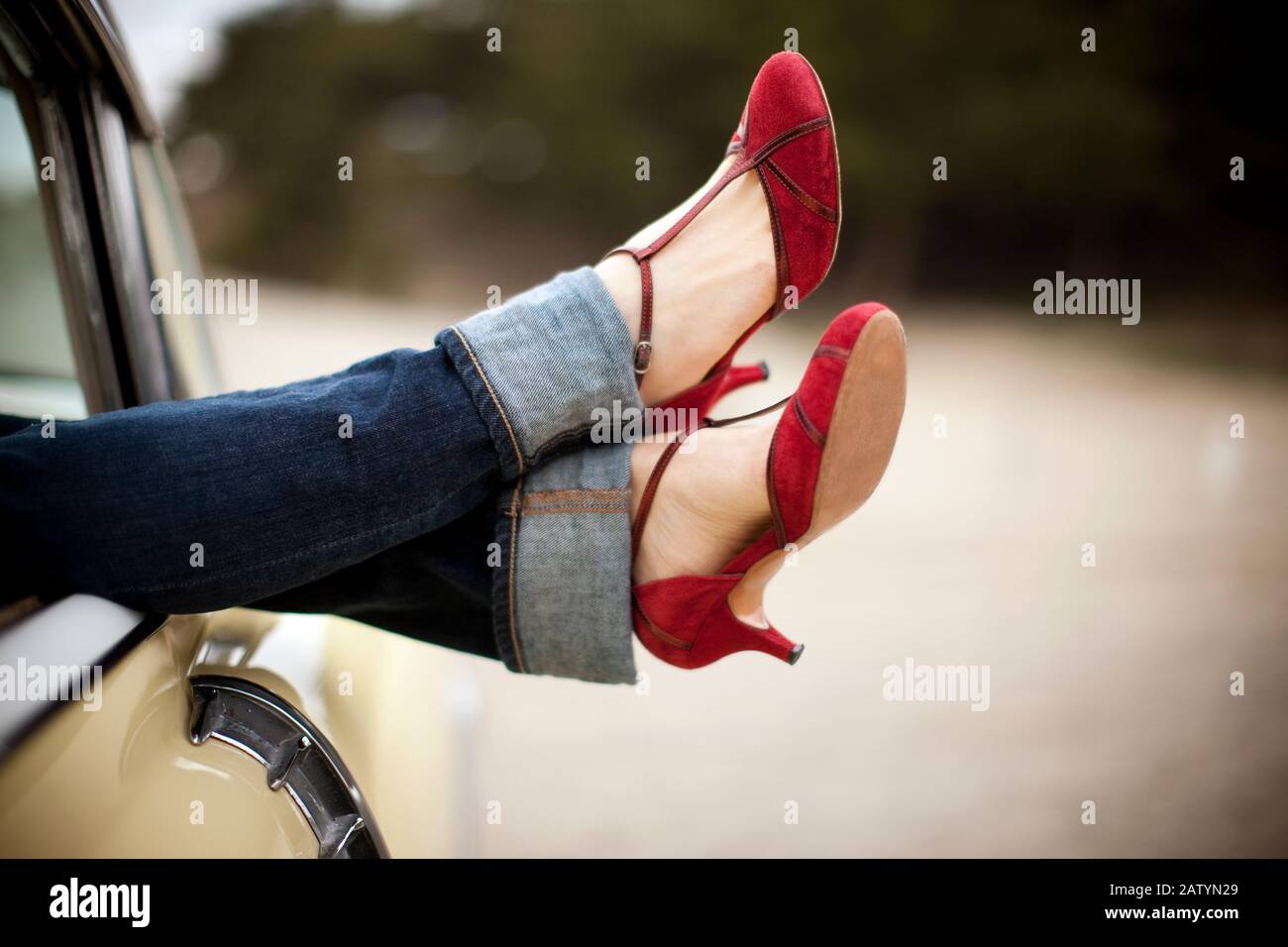 Young woman with legs out the car window Stock Photo - Alamy