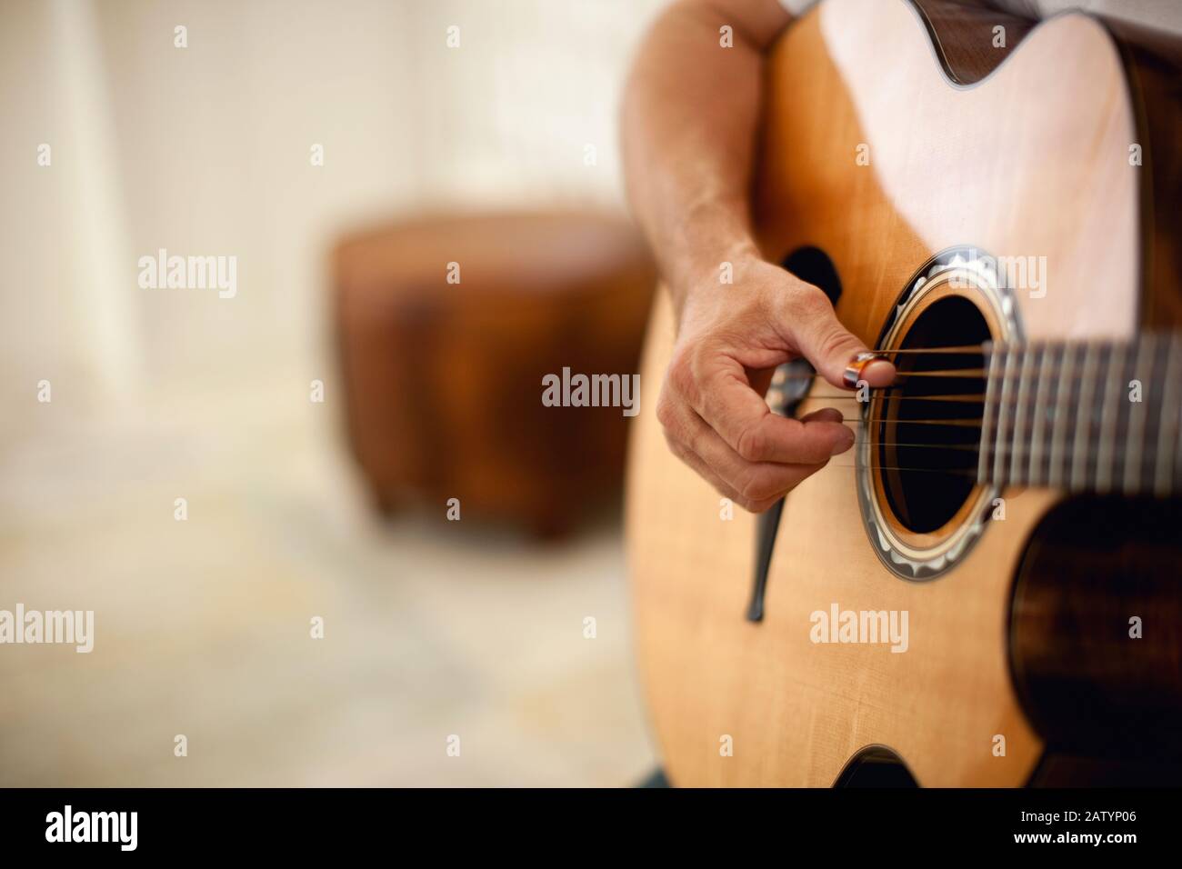 A man's hand playing an acoustic guitar Stock Photo - Alamy