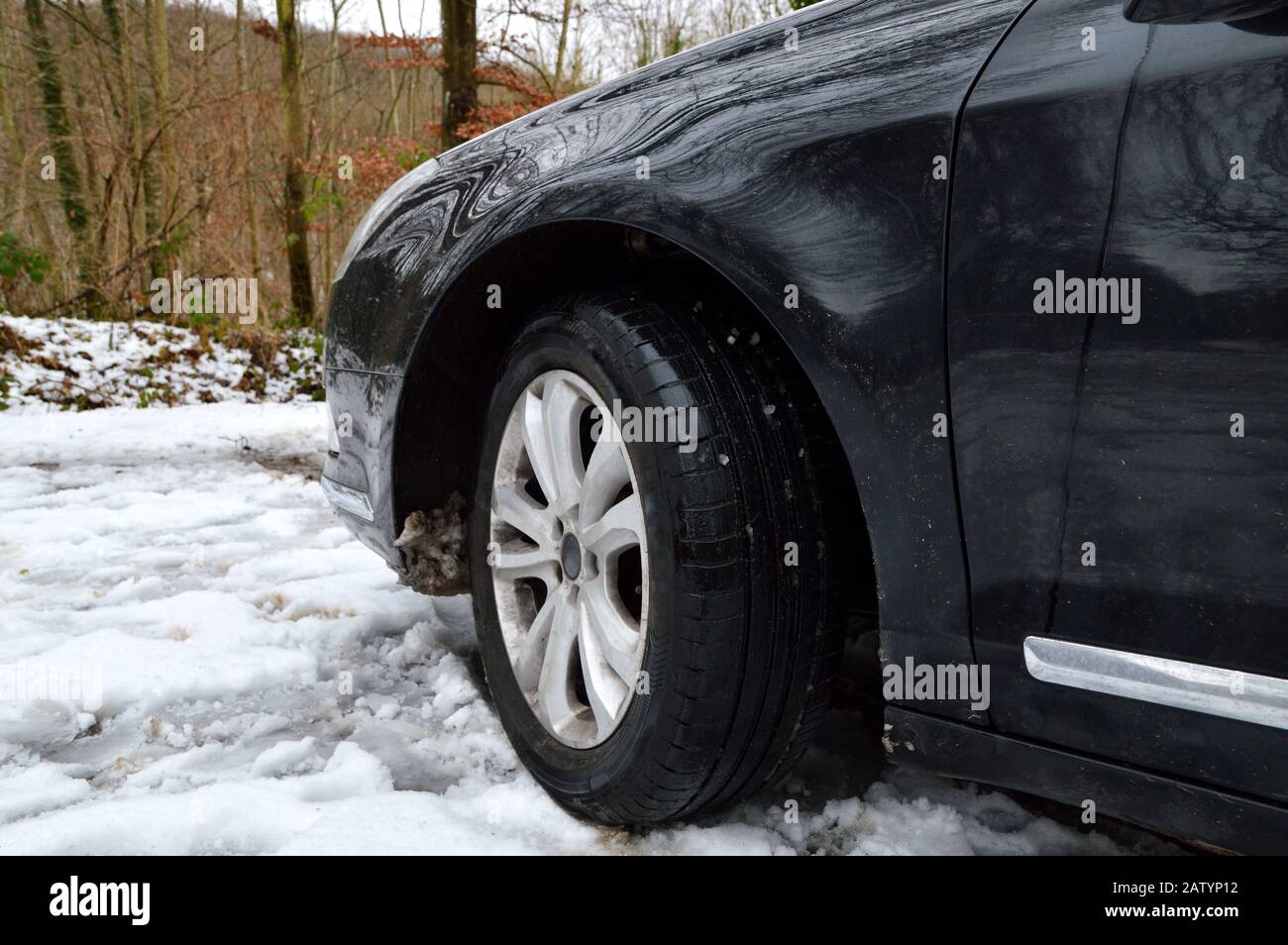 A snowy and slippery road with a car equipped with normal tires ...