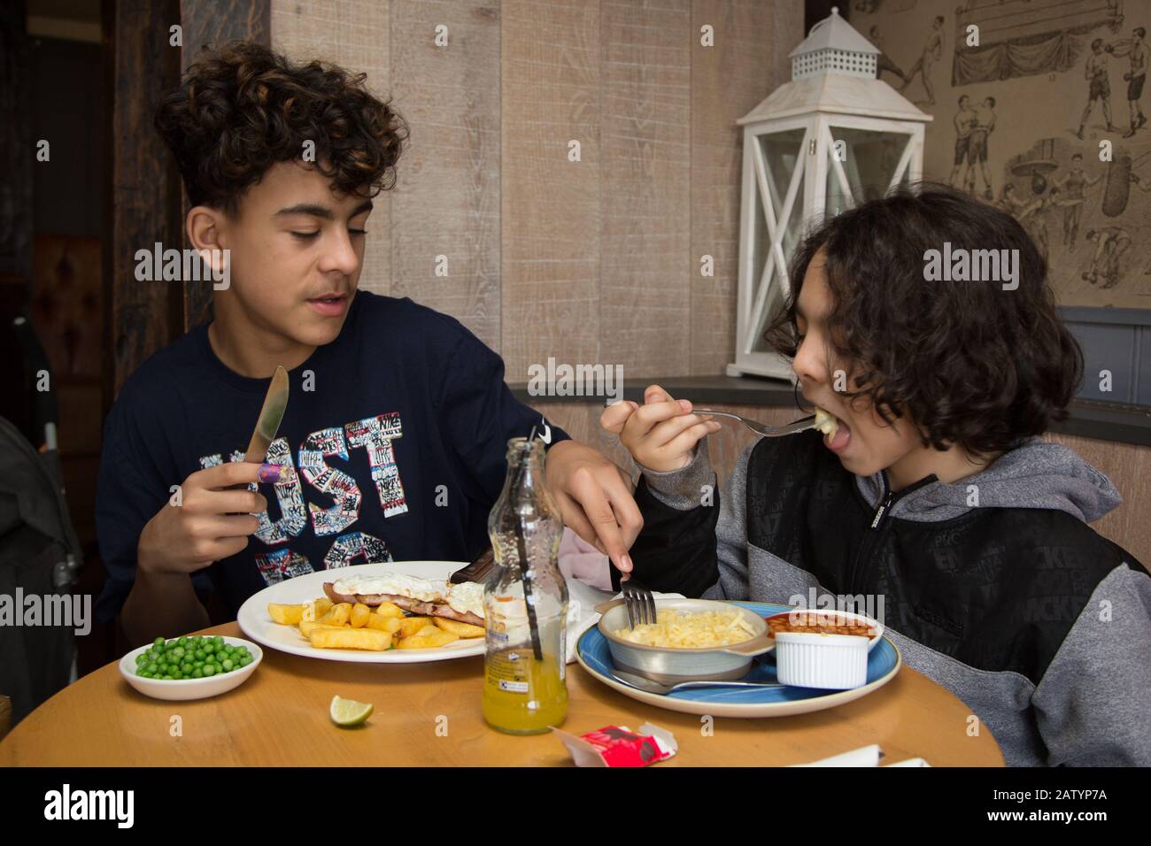 Teens eating at long table hi-res stock photography and images - Alamy