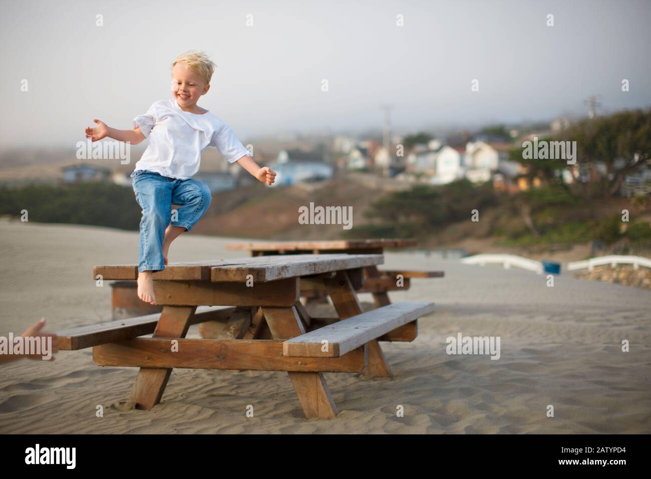 Boy jumping off bench Stock Photo - Alamy