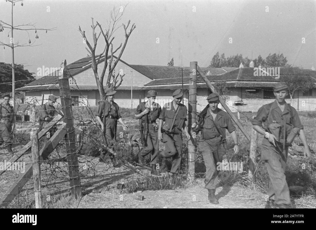Soldiers steps by a deposition of barbed wire around Date: 1946 ...