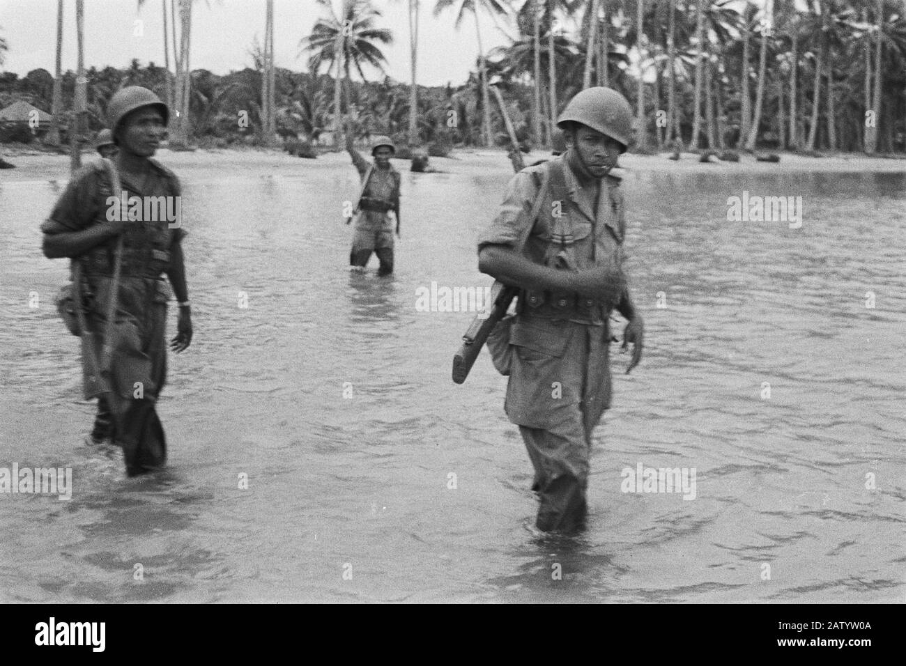 Borneo Soldiers wade through the sea to the sloop Date: February 1947 ...