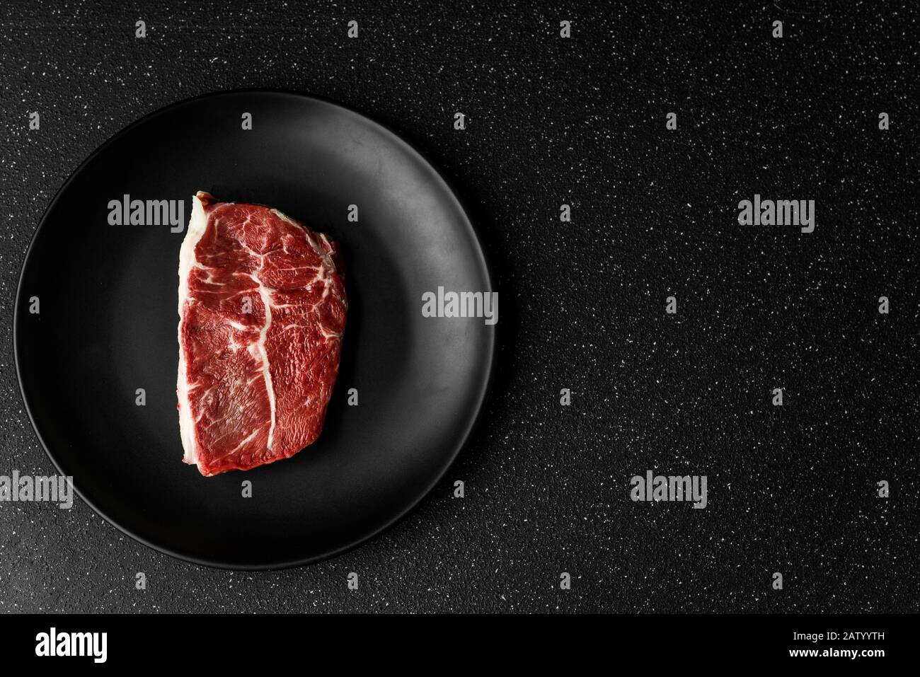 Raw prime beef top blade meat food steak against black stone background ...