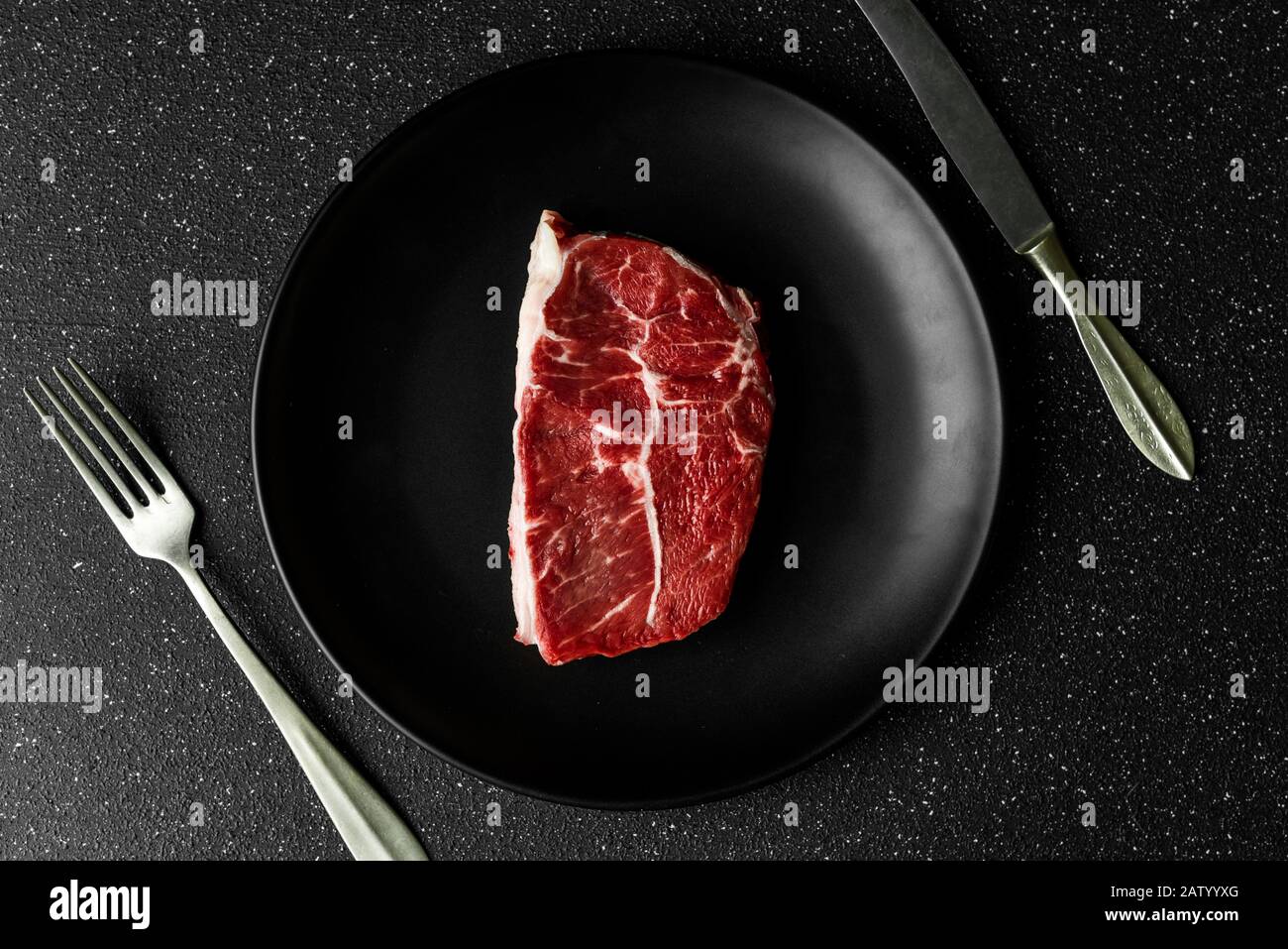 Raw prime beef top blade meat food steak against black stone background ...