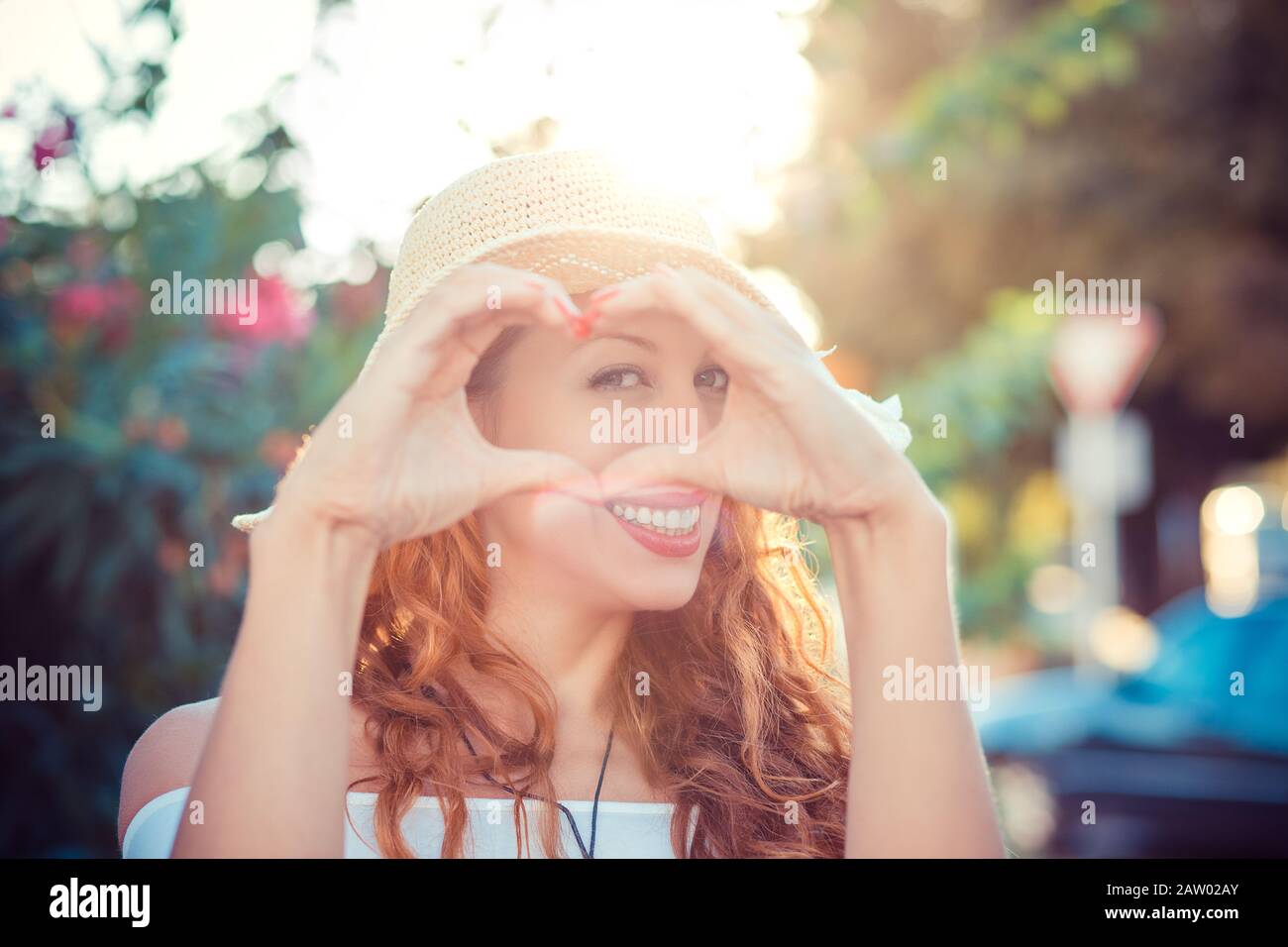 Portrait of young woman making heart symbol with hands Stock Photo - Alamy