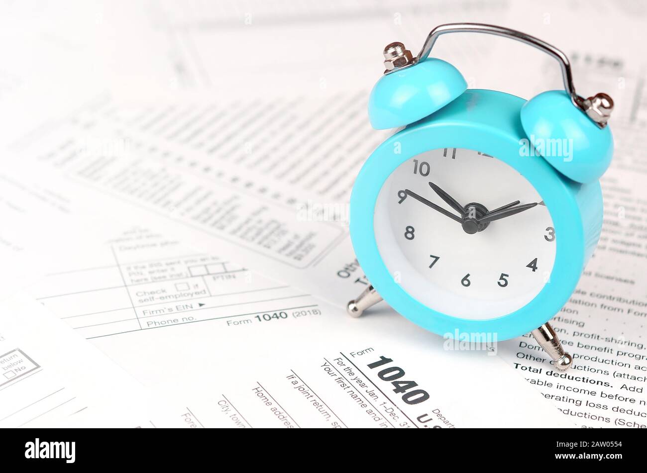 1040 Individual income tax return form with blue alarm clock. Concept ...