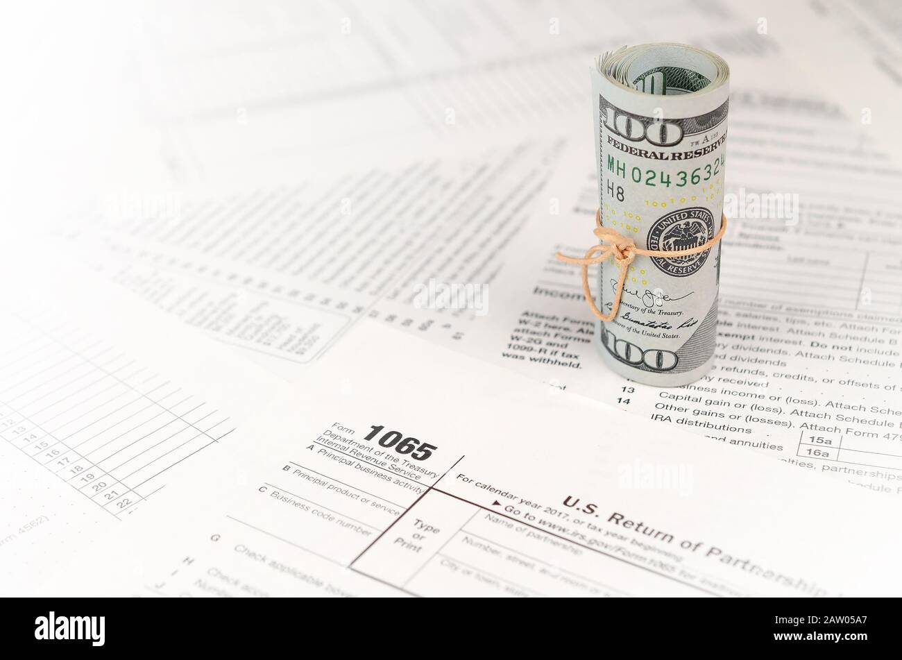 1065 U.S. Return of Parentship Income form with roll of american dollar ...
