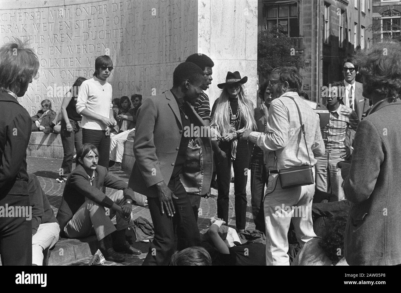 Young sitting and lying on the National Monument on Dam Square in ...