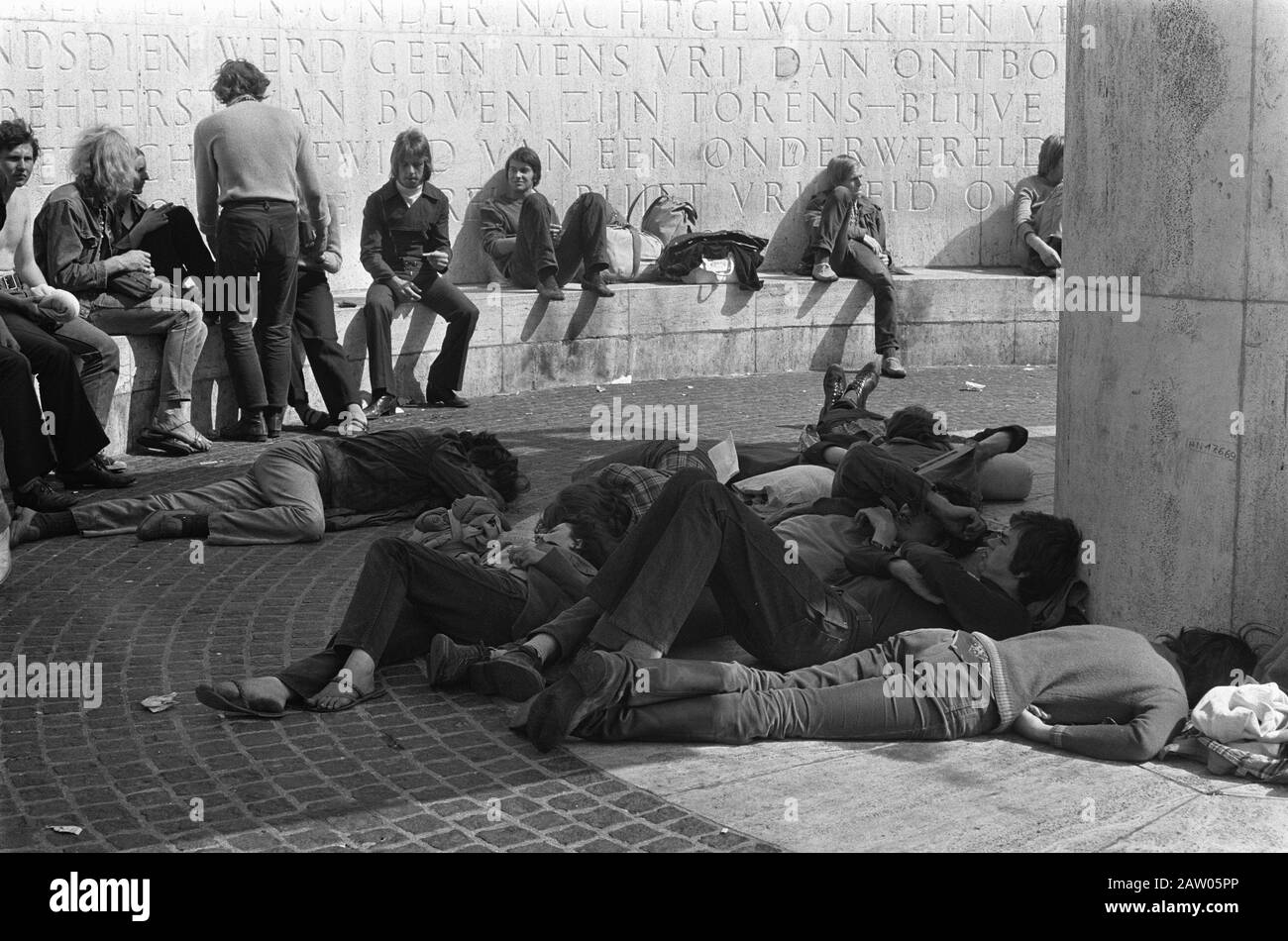 Young sitting and lying on the National Monument on Dam Square in ...