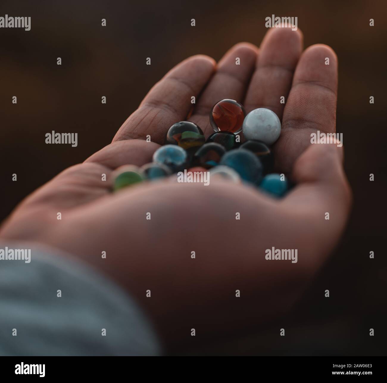 Outside person holding beautiful marble balls in his hands at sunset ...