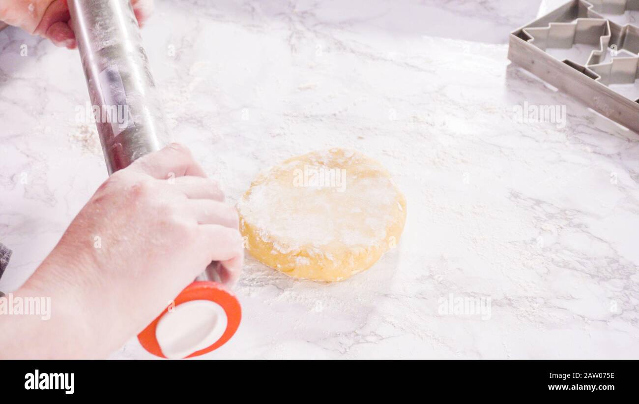 Rolling out sugar cookie dough to bake Christmas cookies Stock Photo ...