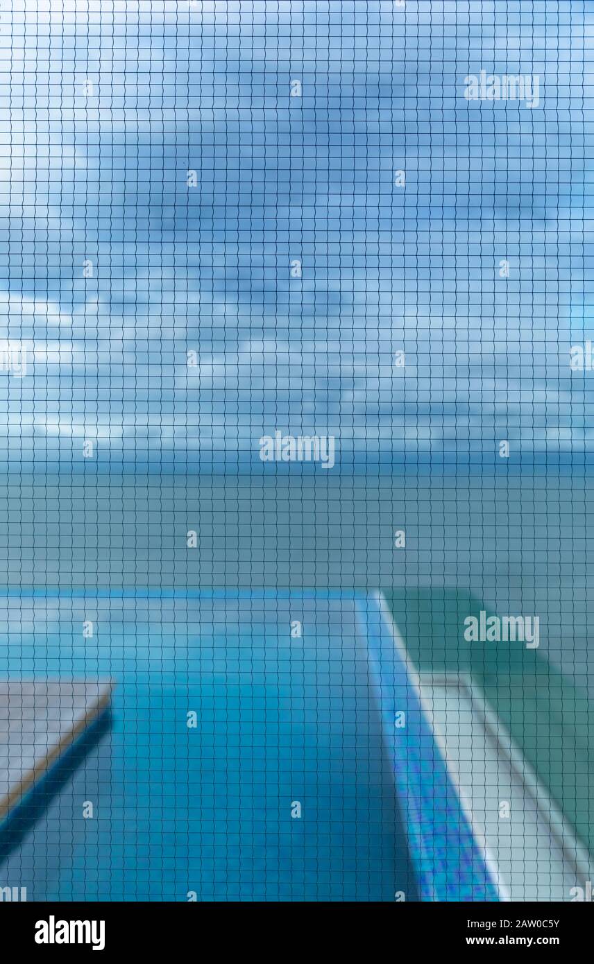 Abstract view of sea, sky and modern infinity pool through a frosted ...
