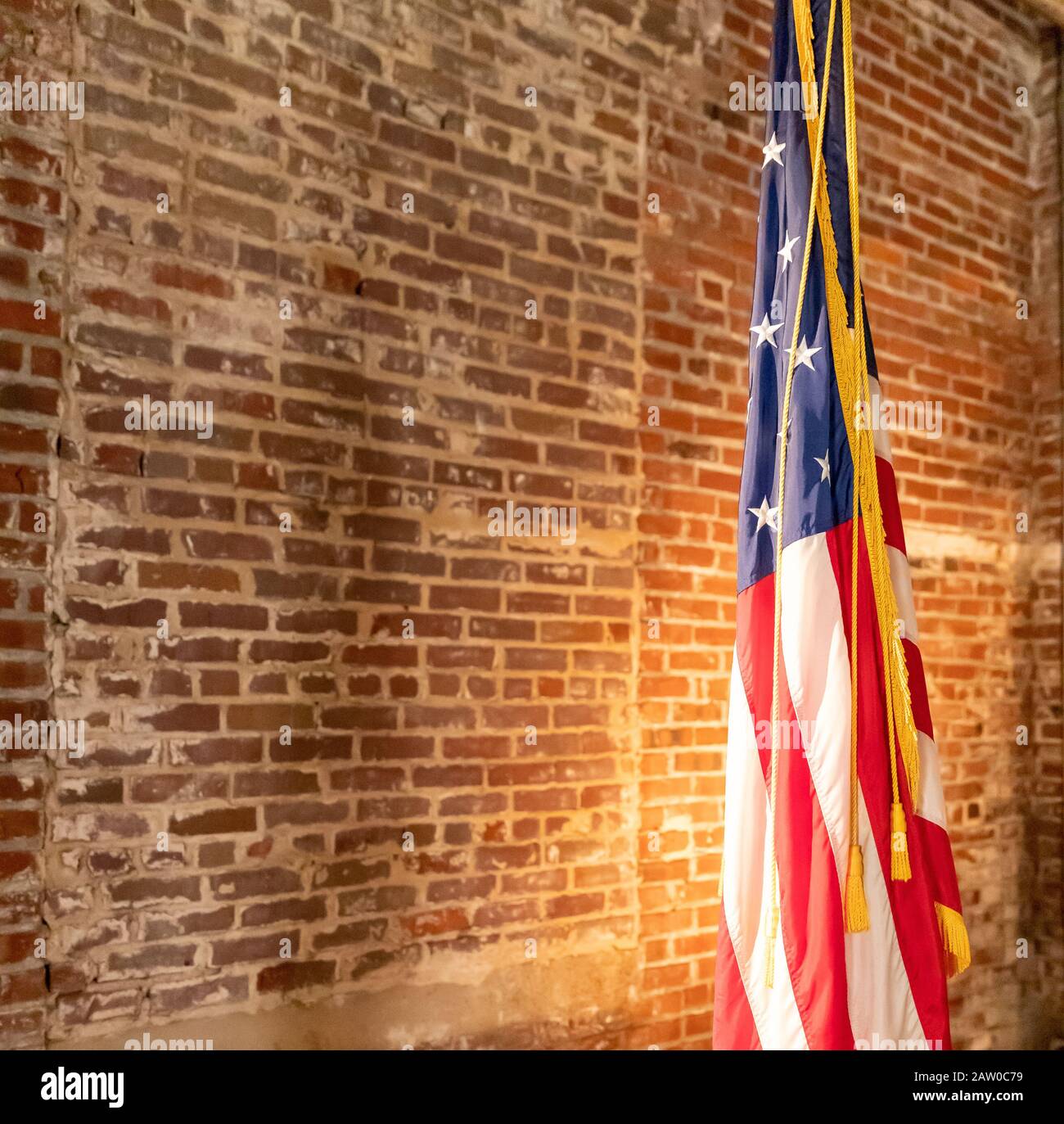 American Flag on Stand, against old brick wall, with copy space Stock ...