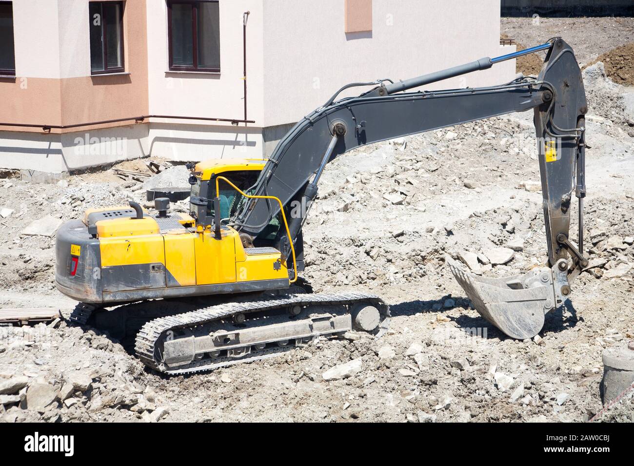 A large construction excavator of yellow color on the construction site ...