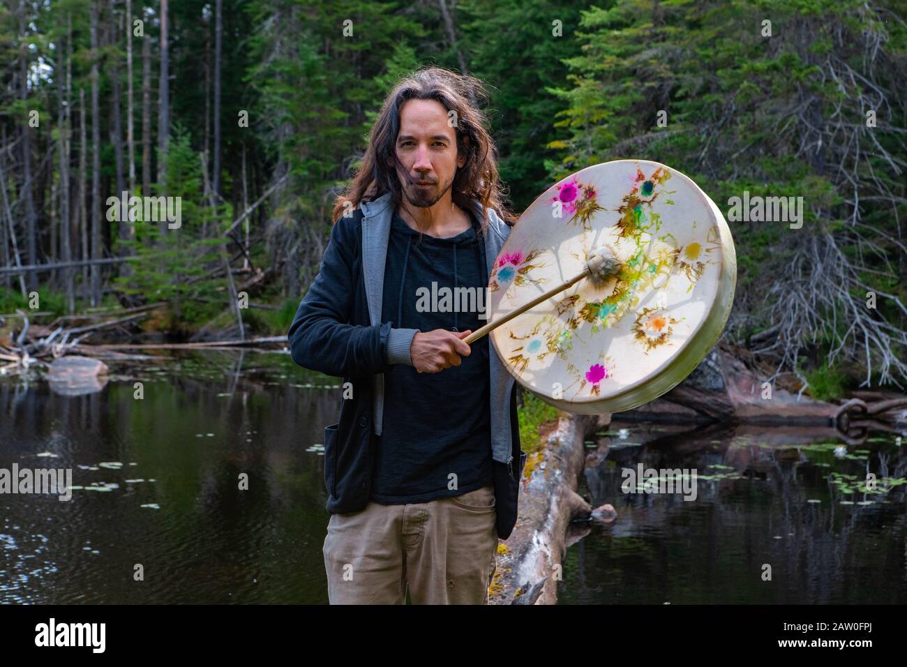 Handsome long haired native american young man playing sacred native ...